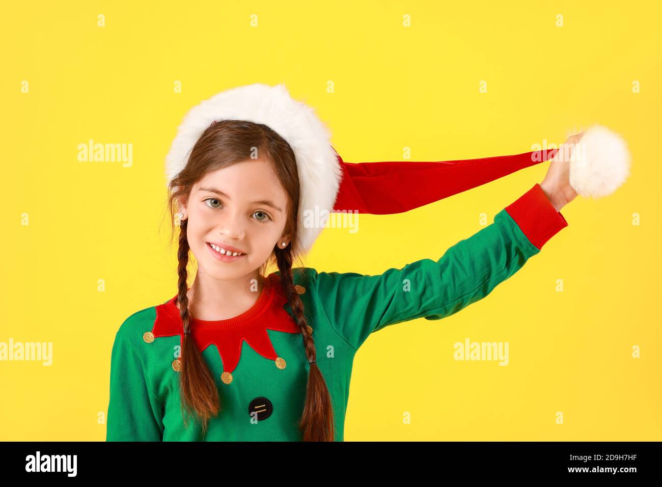 Cute little girl dressed as elf on color background Stock Photo - Alamy