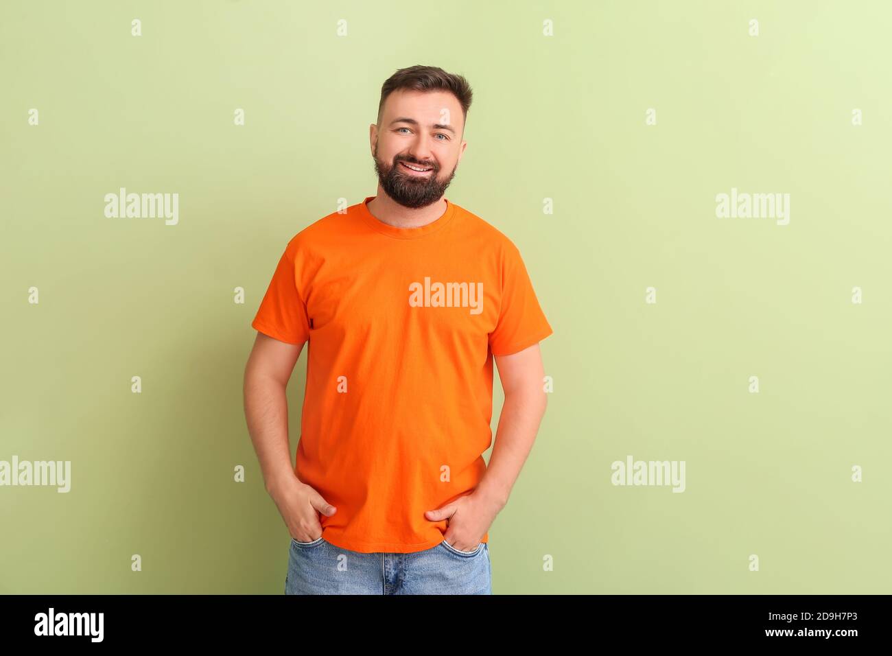 Handsome man in orange t-shirt on color background Stock Photo - Alamy