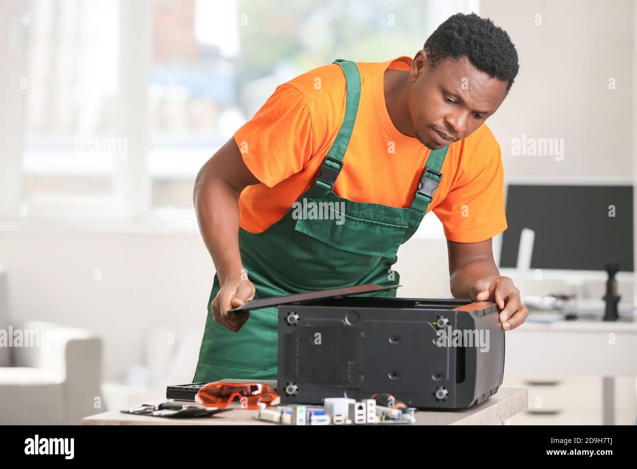 African-American technician repairing computer in service center Stock ...