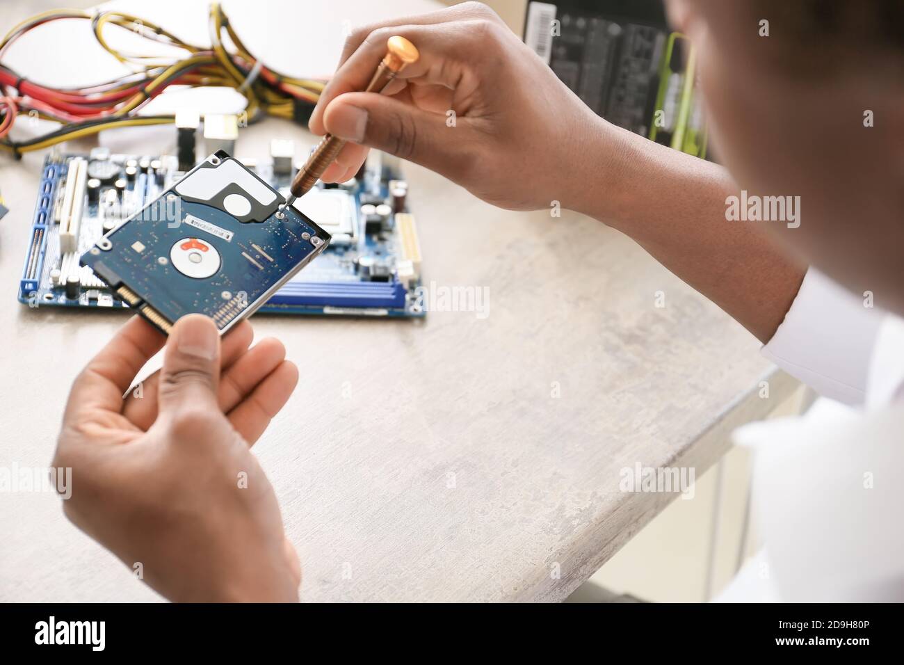 African-American technician repairing computer in service center Stock ...