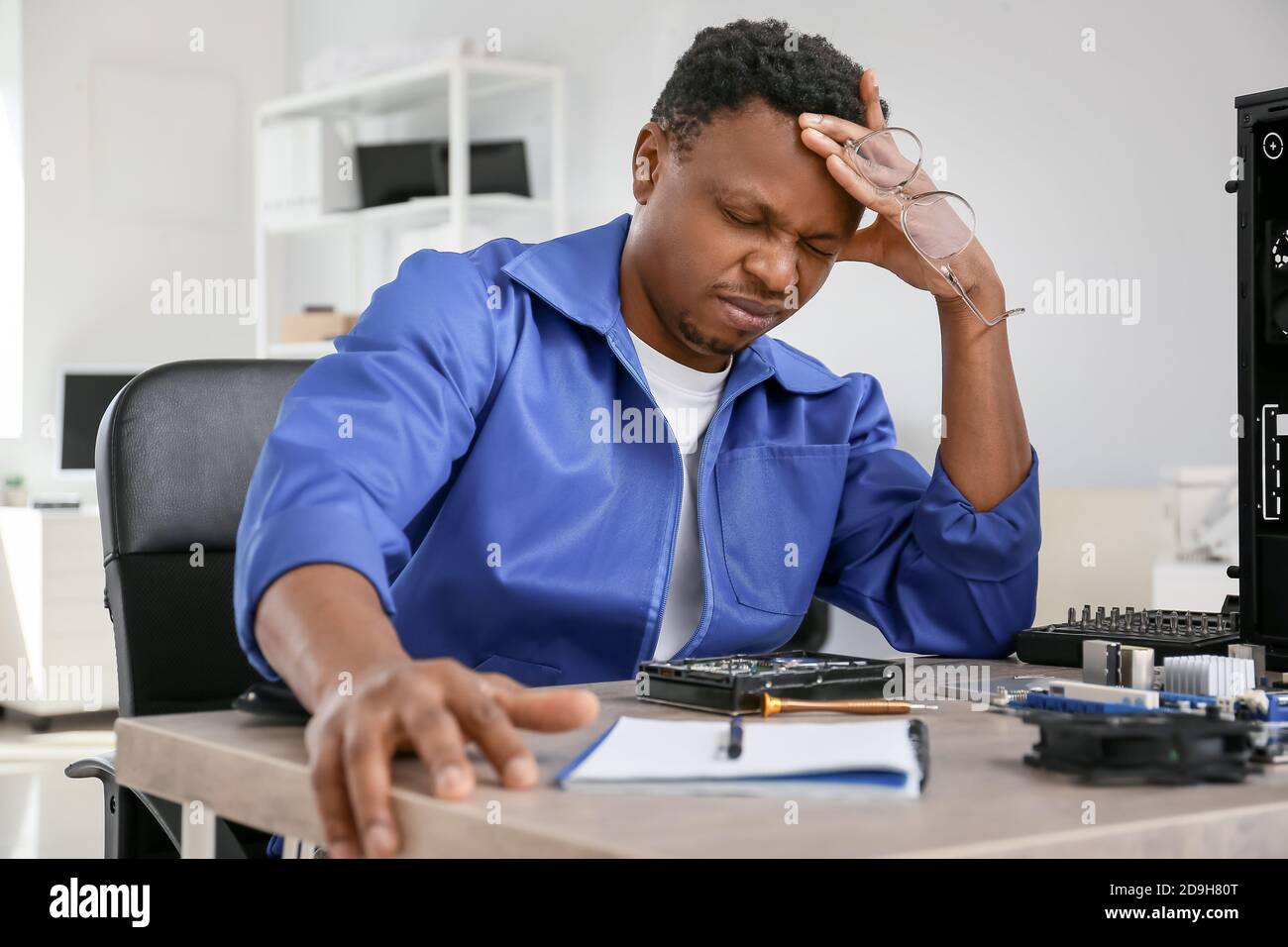 African-American technician repairing computer in service center Stock ...
