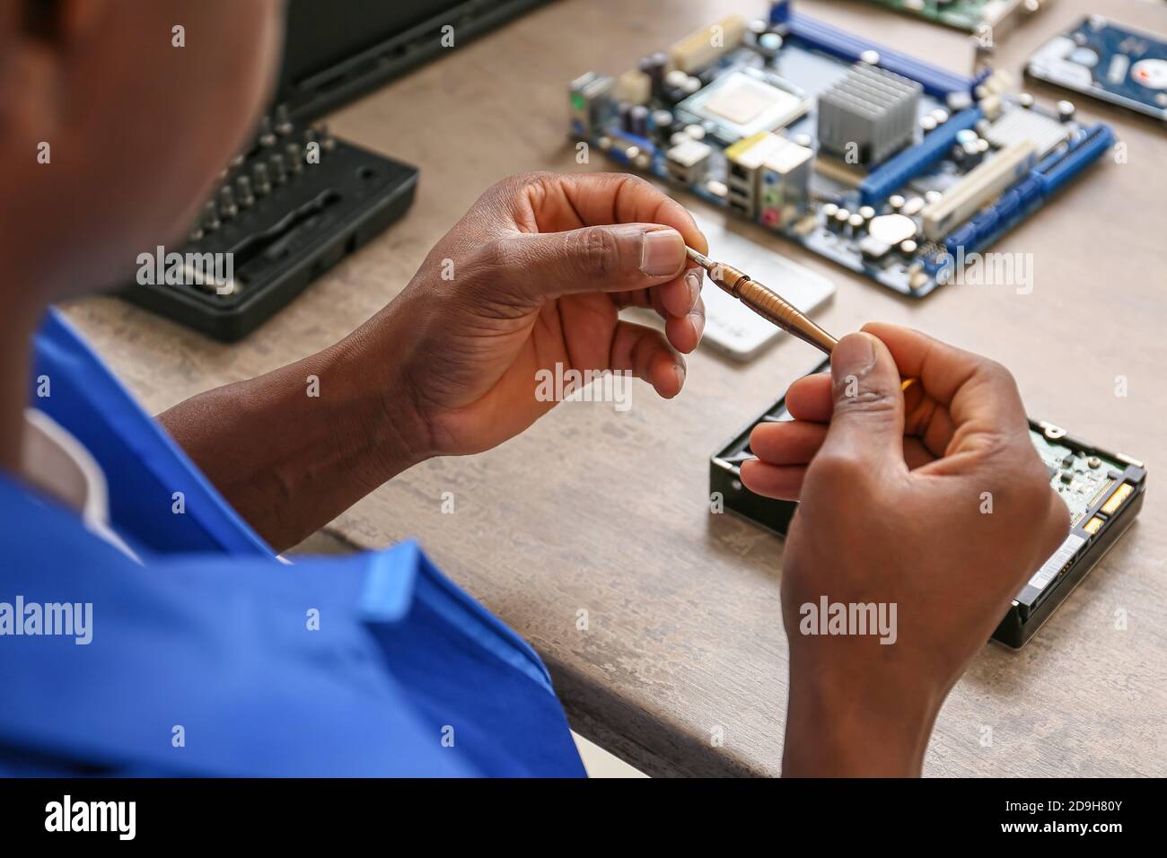 African-American technician repairing computer in service center Stock ...