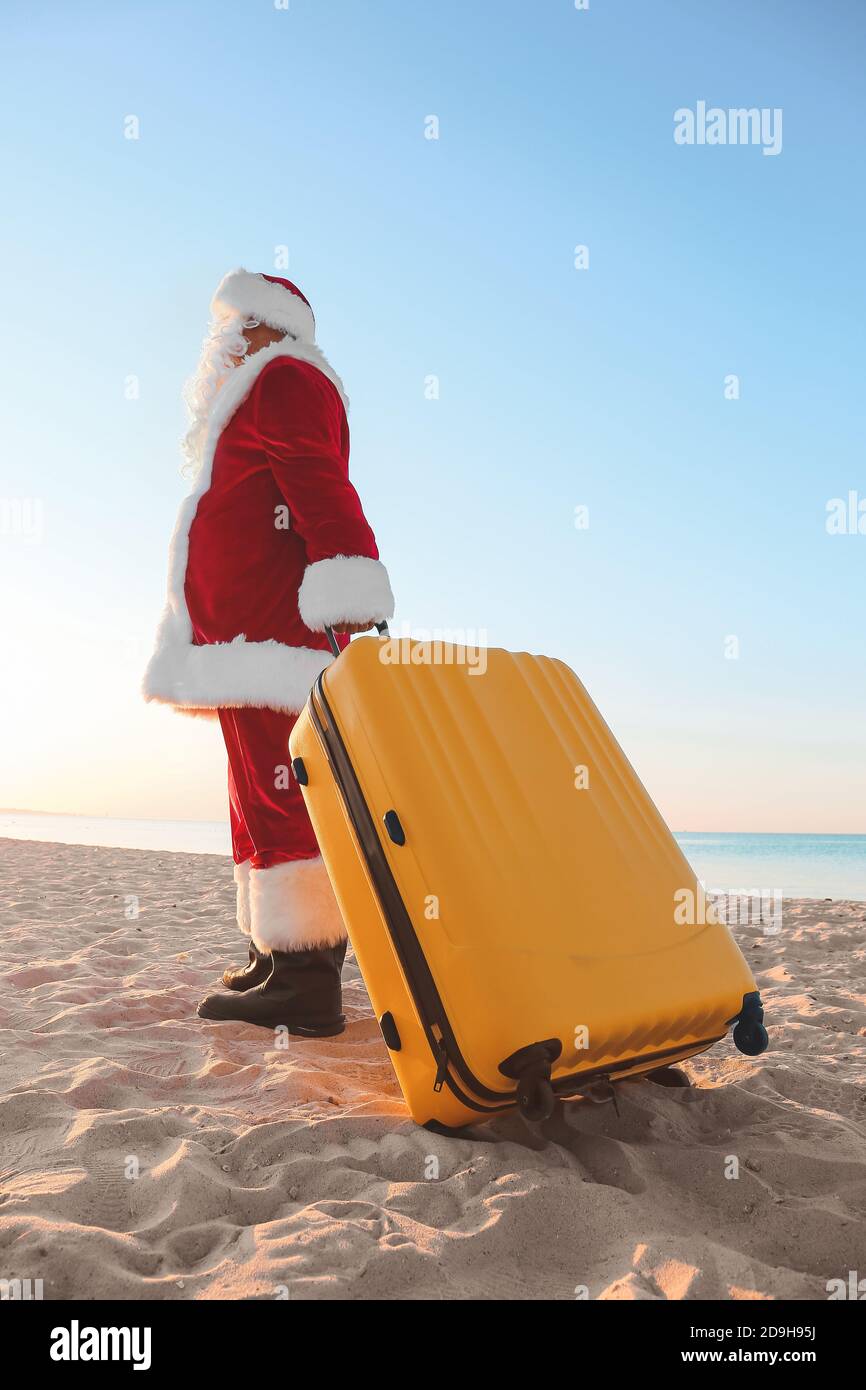 Santa Claus with luggage at sea resort. Christmas vacation Stock Photo ...