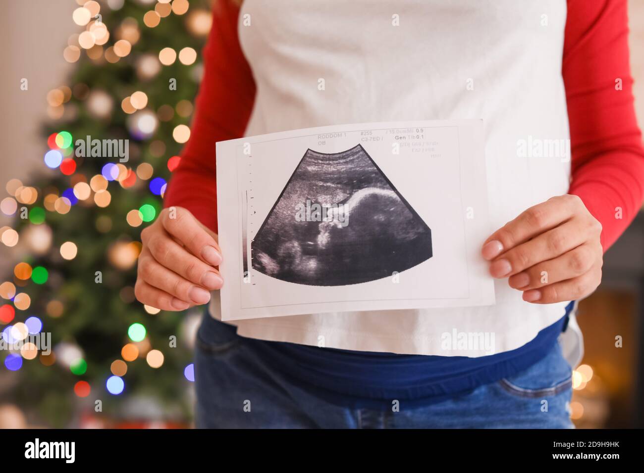 Beautiful pregnant woman with sonogram image at home on Christmas eve ...