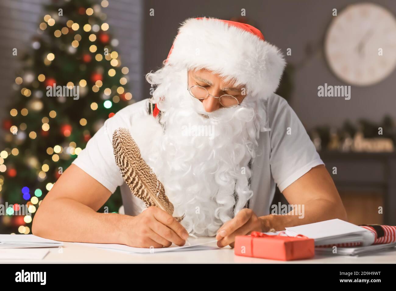 Santa Claus making list of gifts at table Stock Photo - Alamy