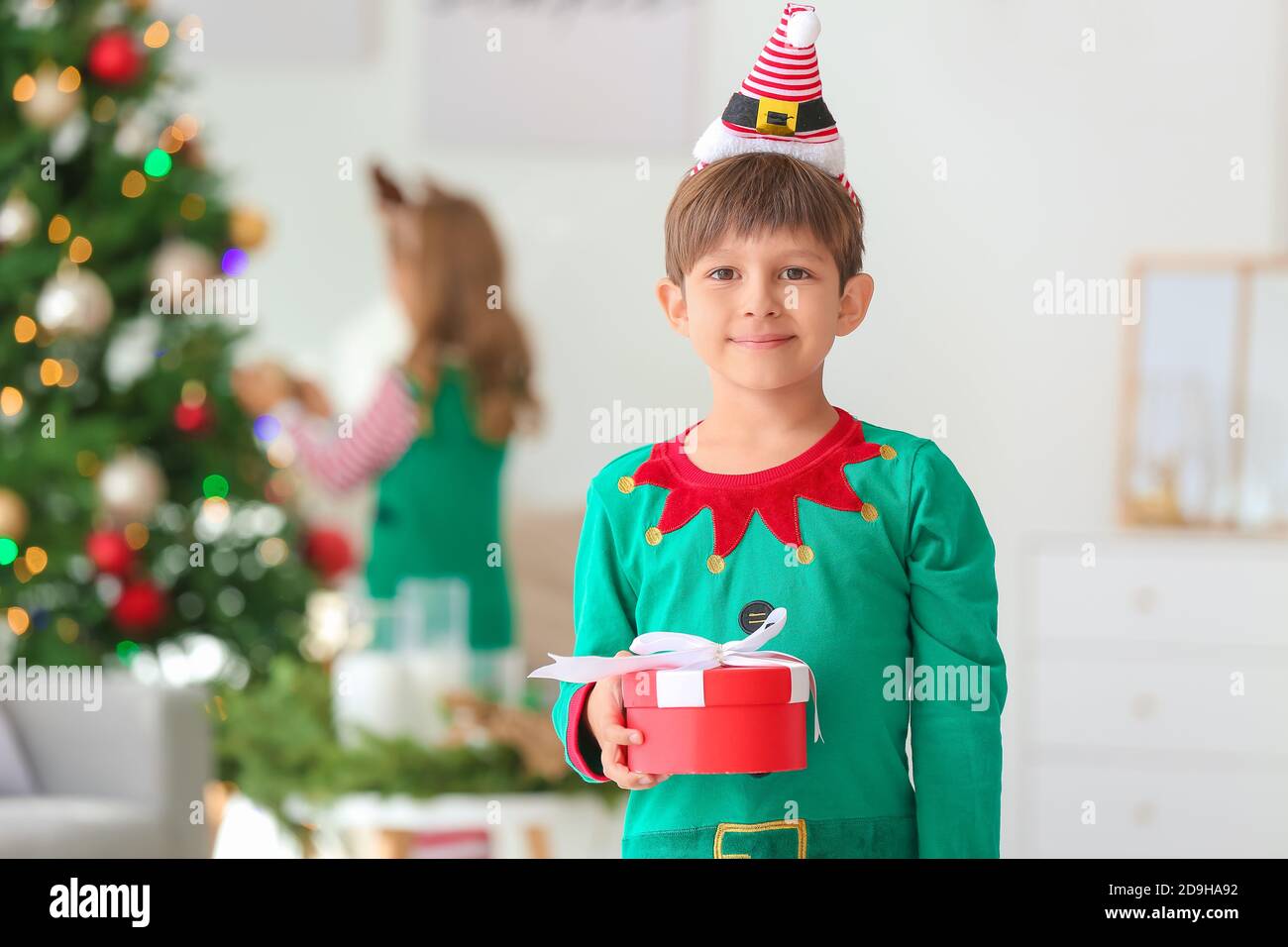 Cute little elf with gift at home on Christmas eve Stock Photo - Alamy