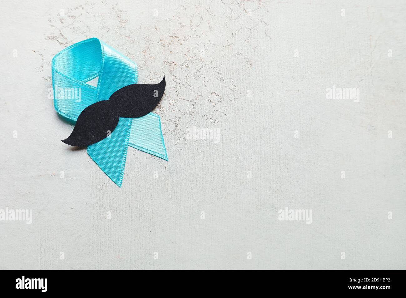 Blue ribbon and mustache on light background. Prostate cancer awareness ...