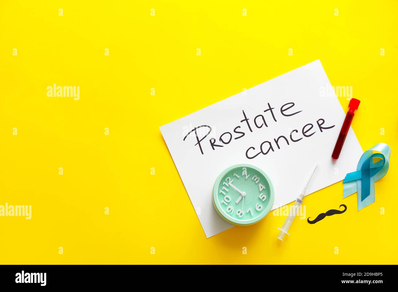 Paper sheet with text PROSTATE CANCER, clock, ribbon, mustache, syringe ...