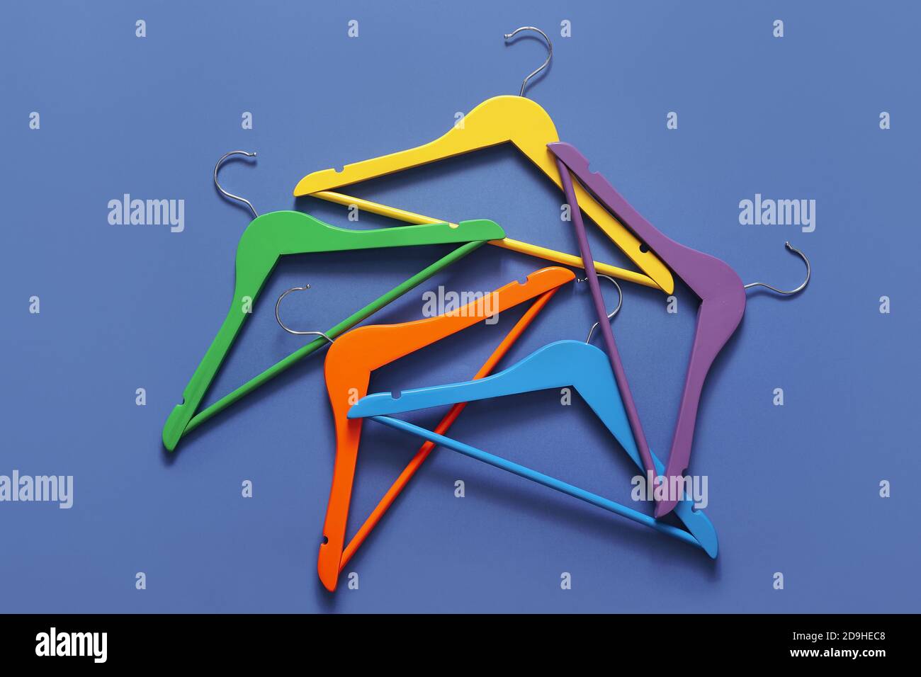 Clothes hangers on color background Stock Photo - Alamy