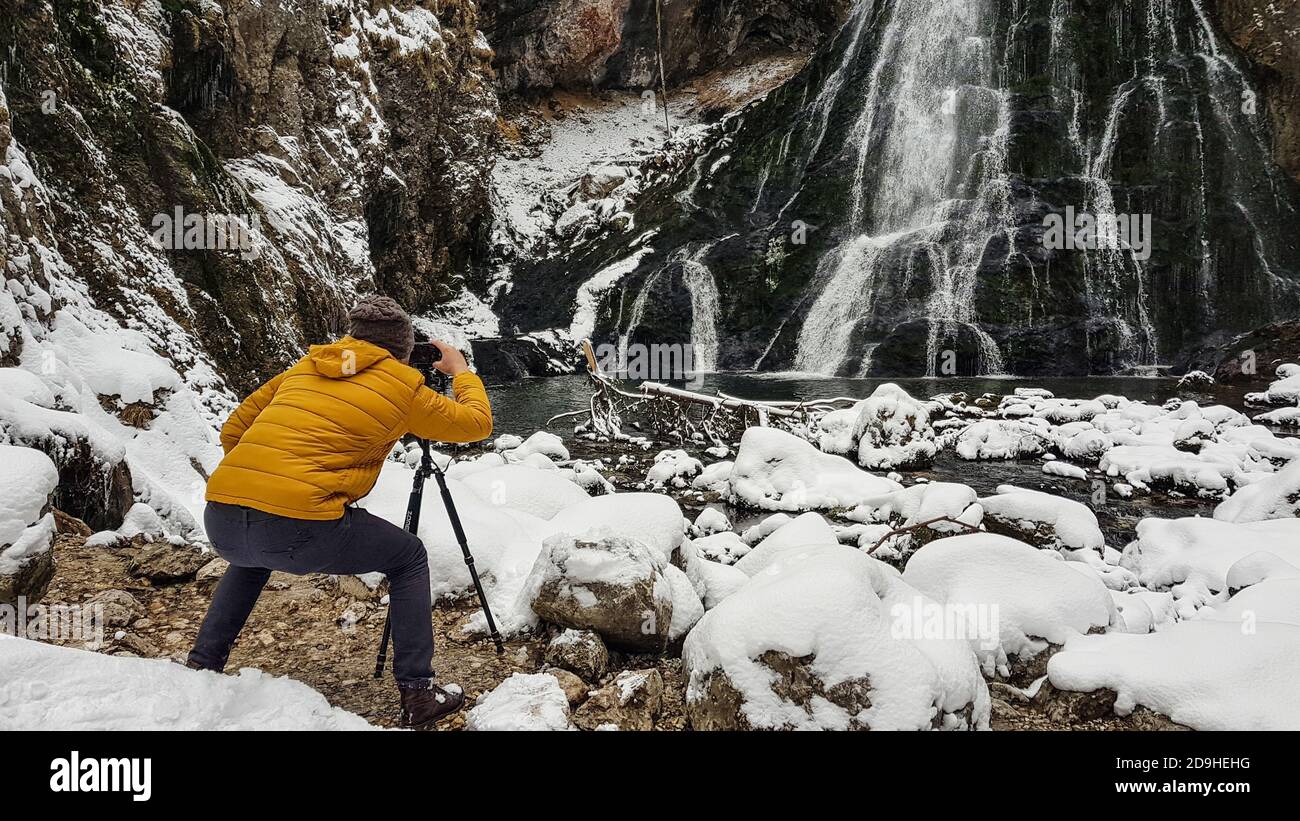 Man photographing the Golling Waterfalls in Austria on a cold winter ...