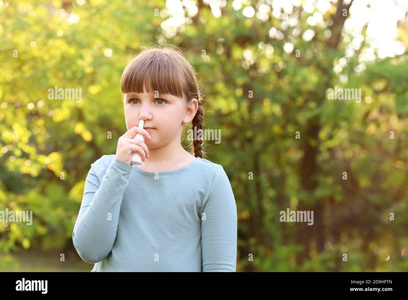 Little allergic girl with nasal drops outdoors Stock Photo - Alamy