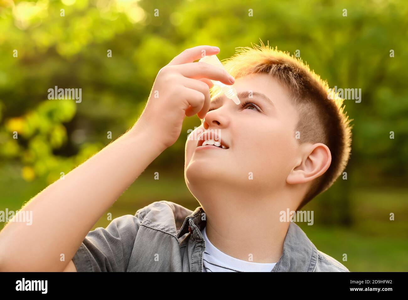 Little allergic boy using eye drops outdoors Stock Photo - Alamy