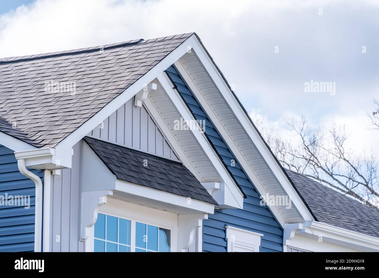 Decorative double gable with blue horizontal siding on a house Stock ...