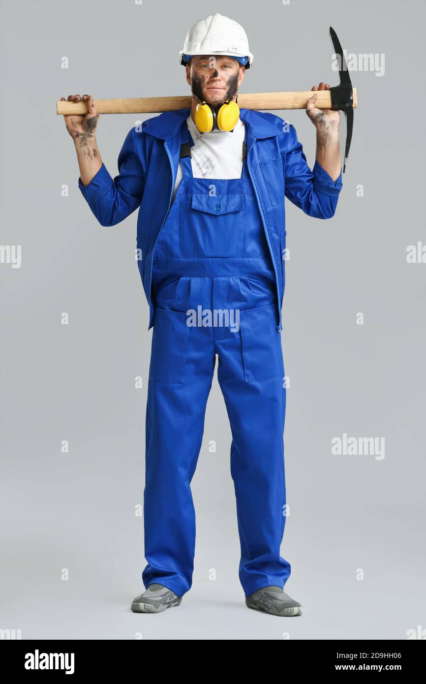 Miner man with pick axe on grey background Stock Photo - Alamy