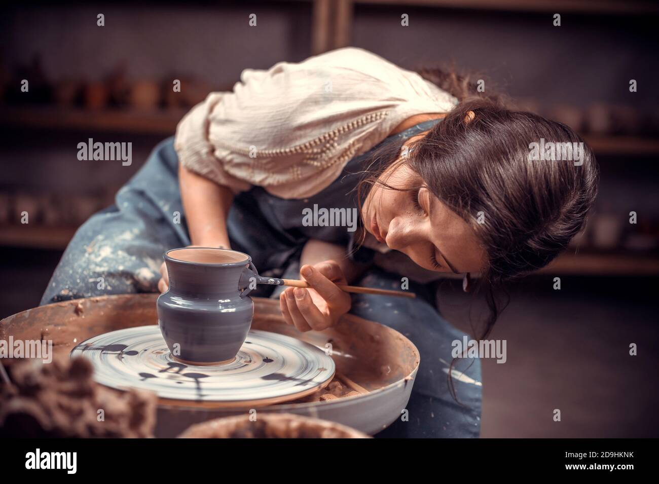 Hands of the master potter and vase of clay on the potter's wheel close ...