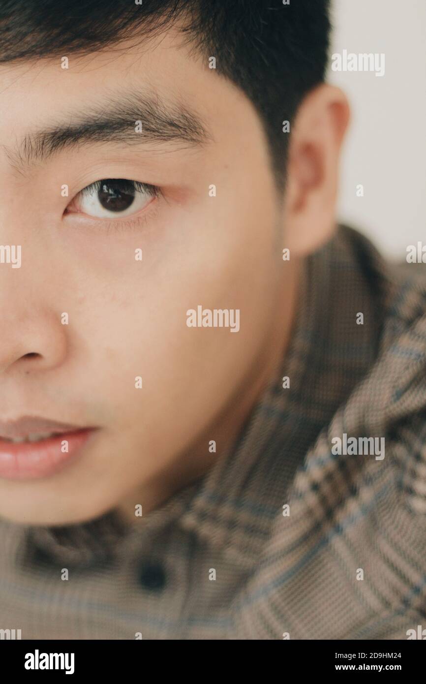 Vertical closeup half face portrait of an Asian handsome man with a ...