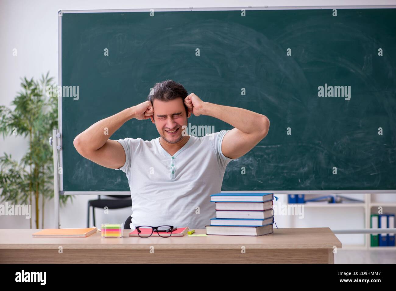 Young teacher student sitting in the classroom Stock Photo - Alamy