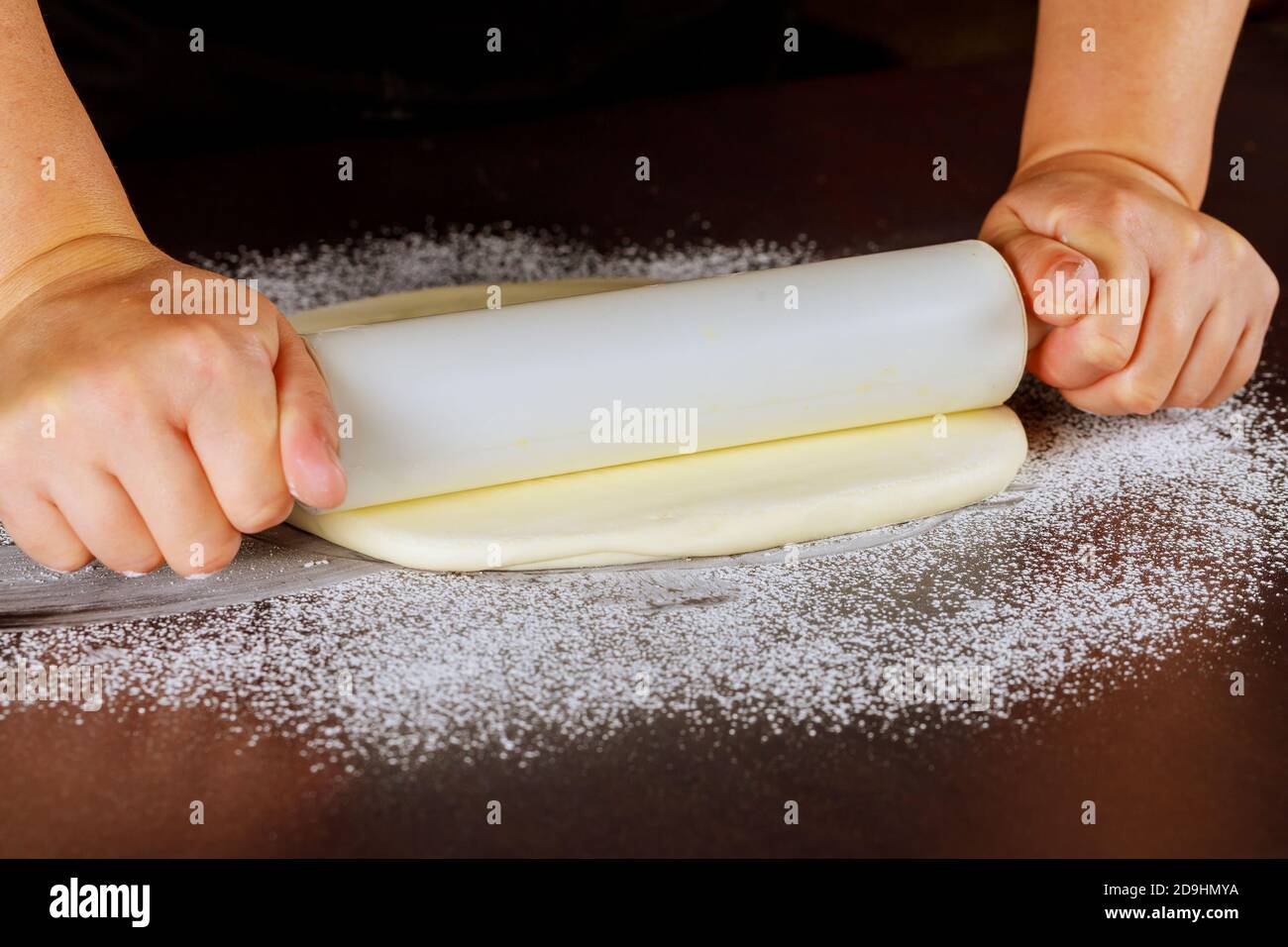 Chef using rolling pin on white fondant. Making cake decoration Stock ...