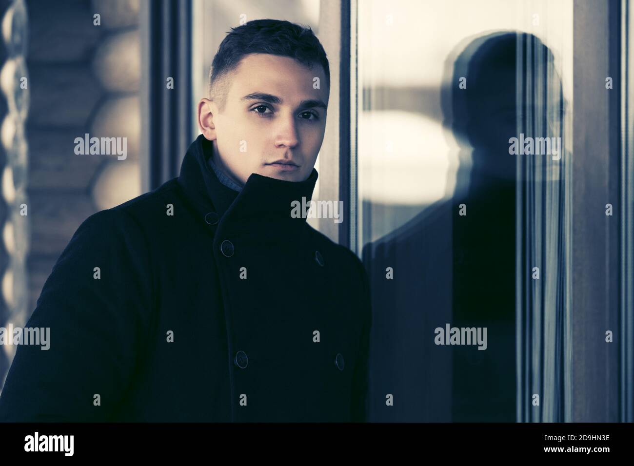 Young handsome man leaning on the window Stylish male fashion model in ...