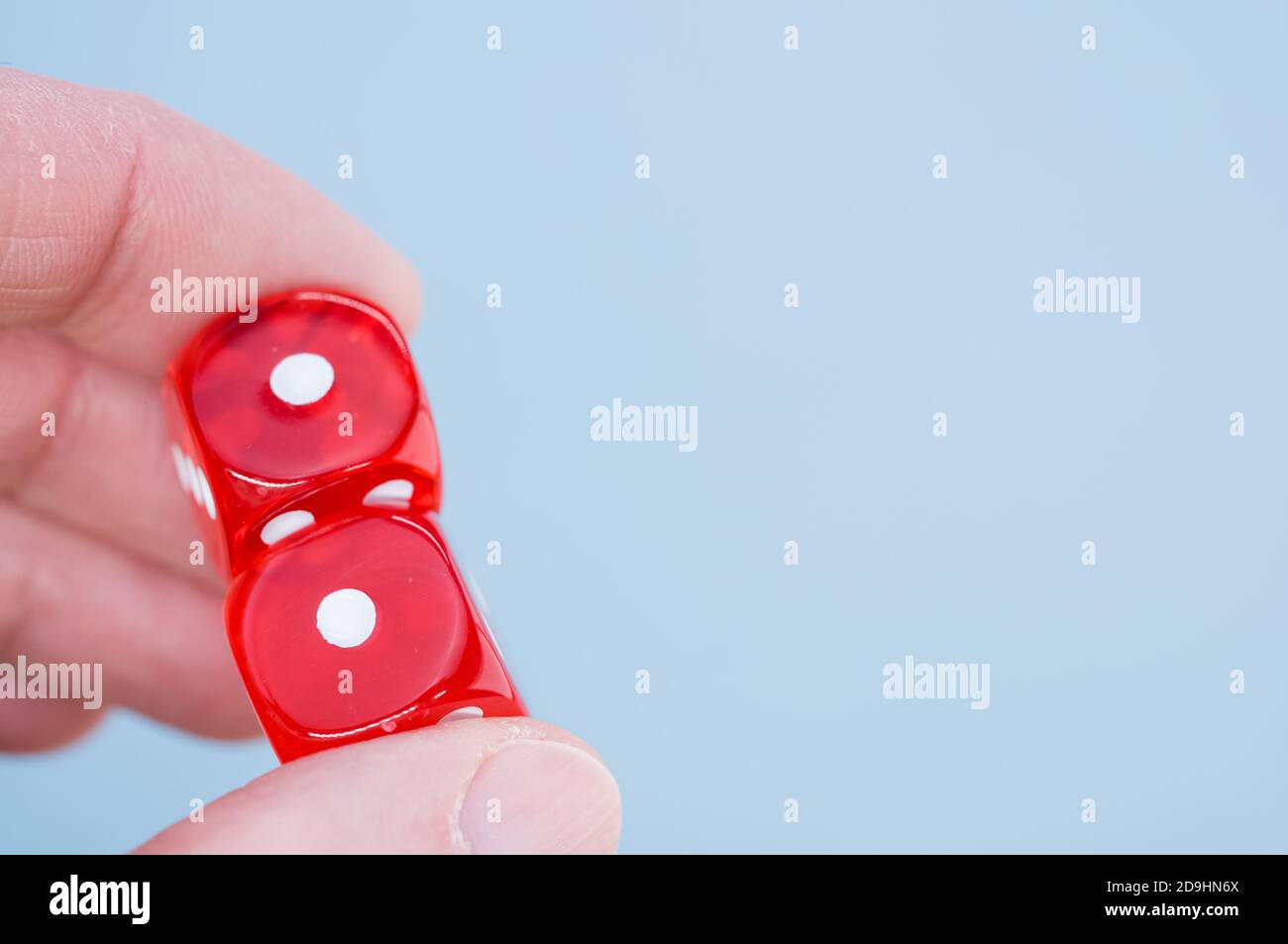 High angle shot of a person holding playing dice on an isolated blue ...