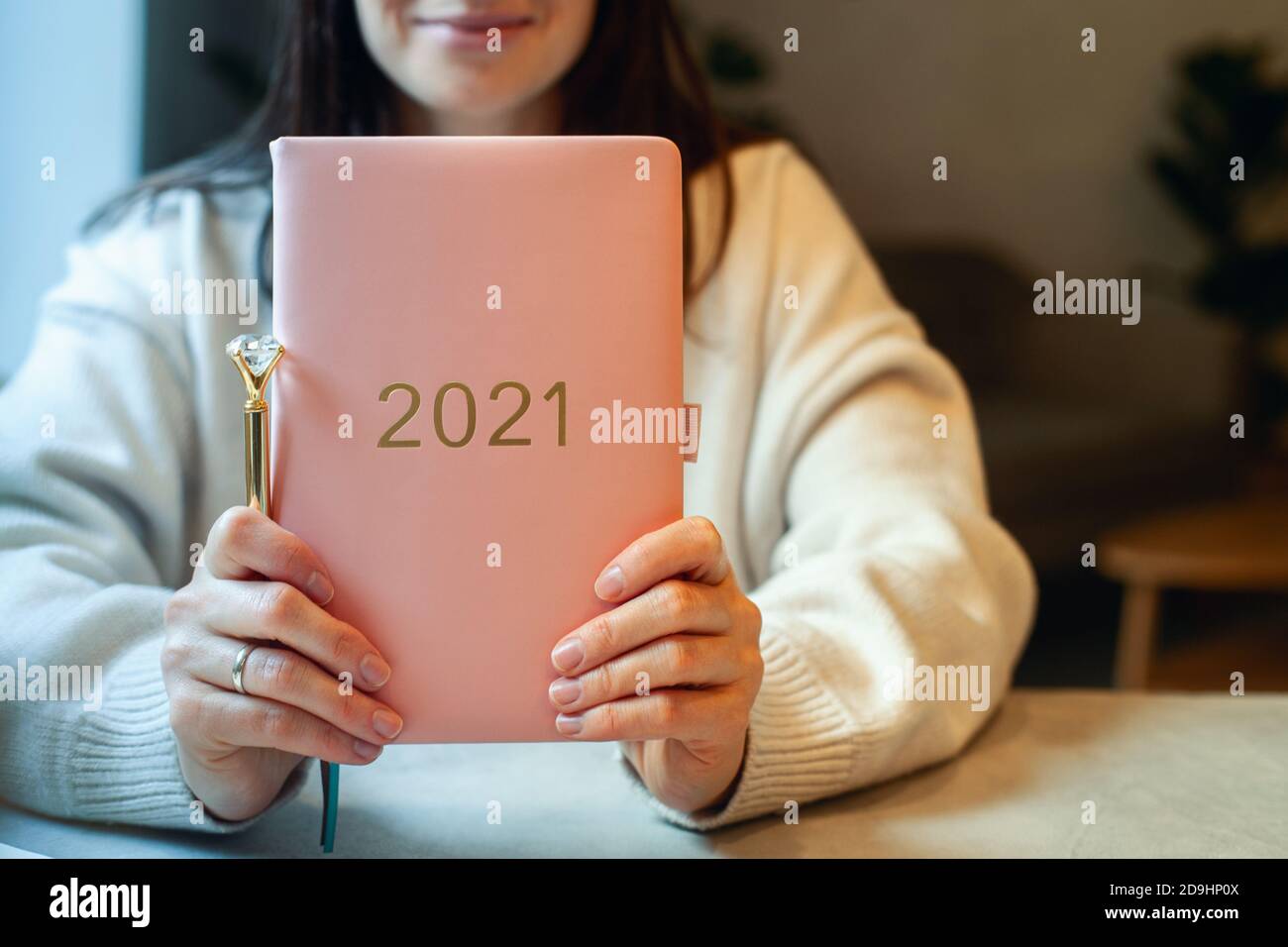 Inspired young woman with a smile looking through window and holding ...