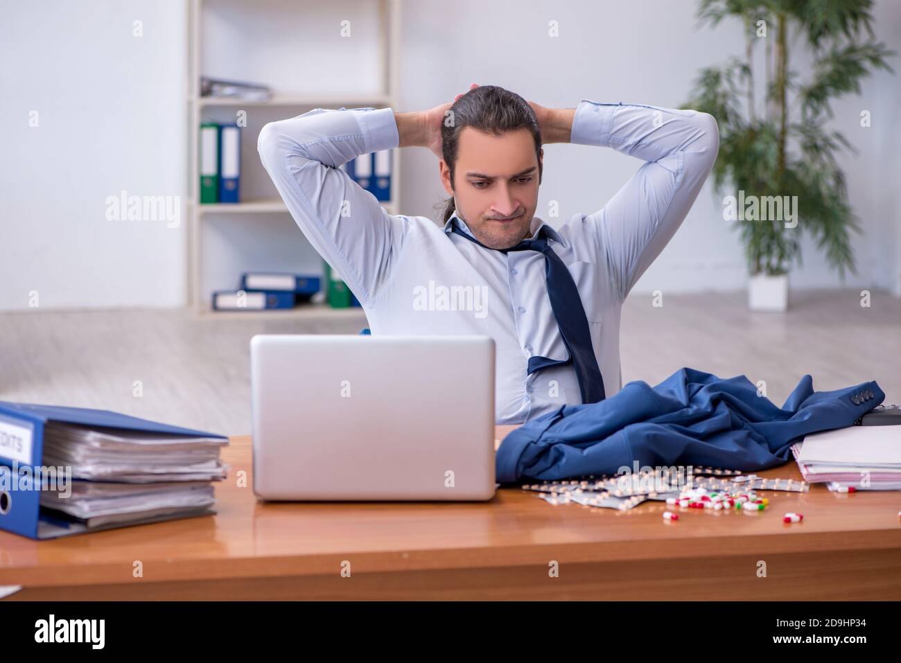 Sick male employee suffering at workplace Stock Photo - Alamy