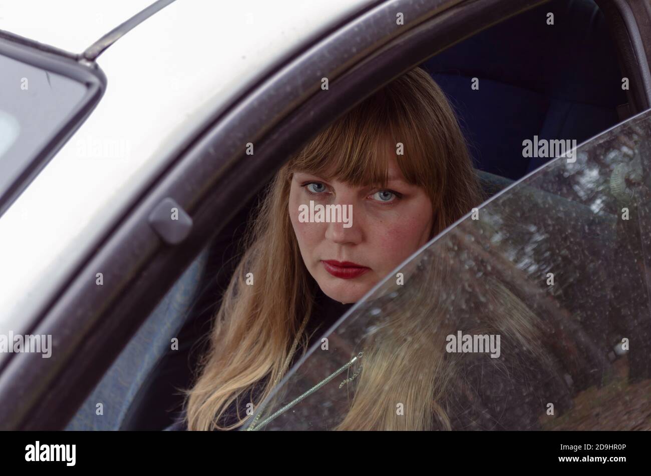 Portrait an adult female driver looking out the open window while ...