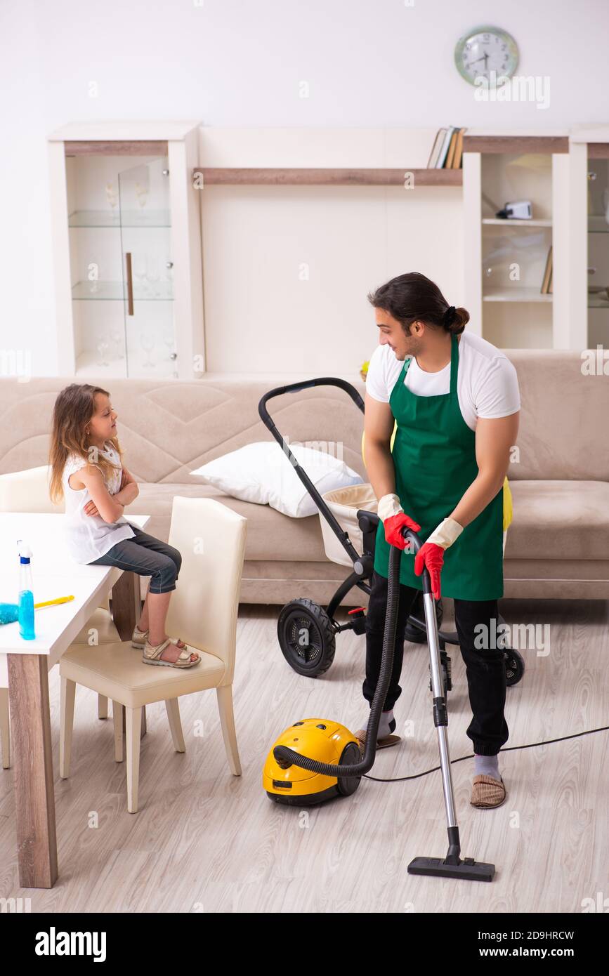Young contractor cleaning the house with his small daughter Stock Photo ...