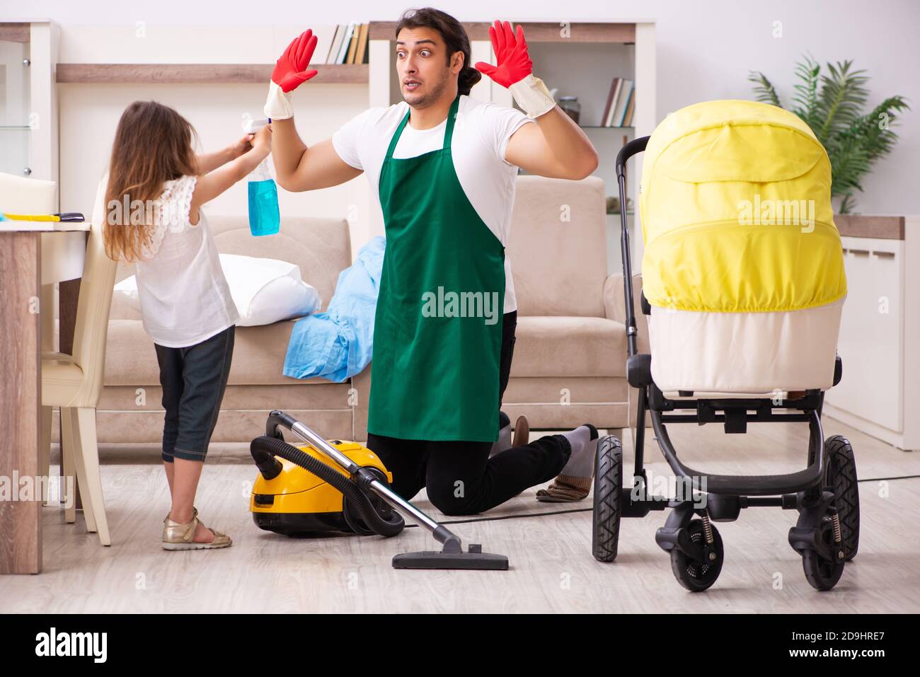 Young contractor cleaning the house with his small daughter Stock Photo ...