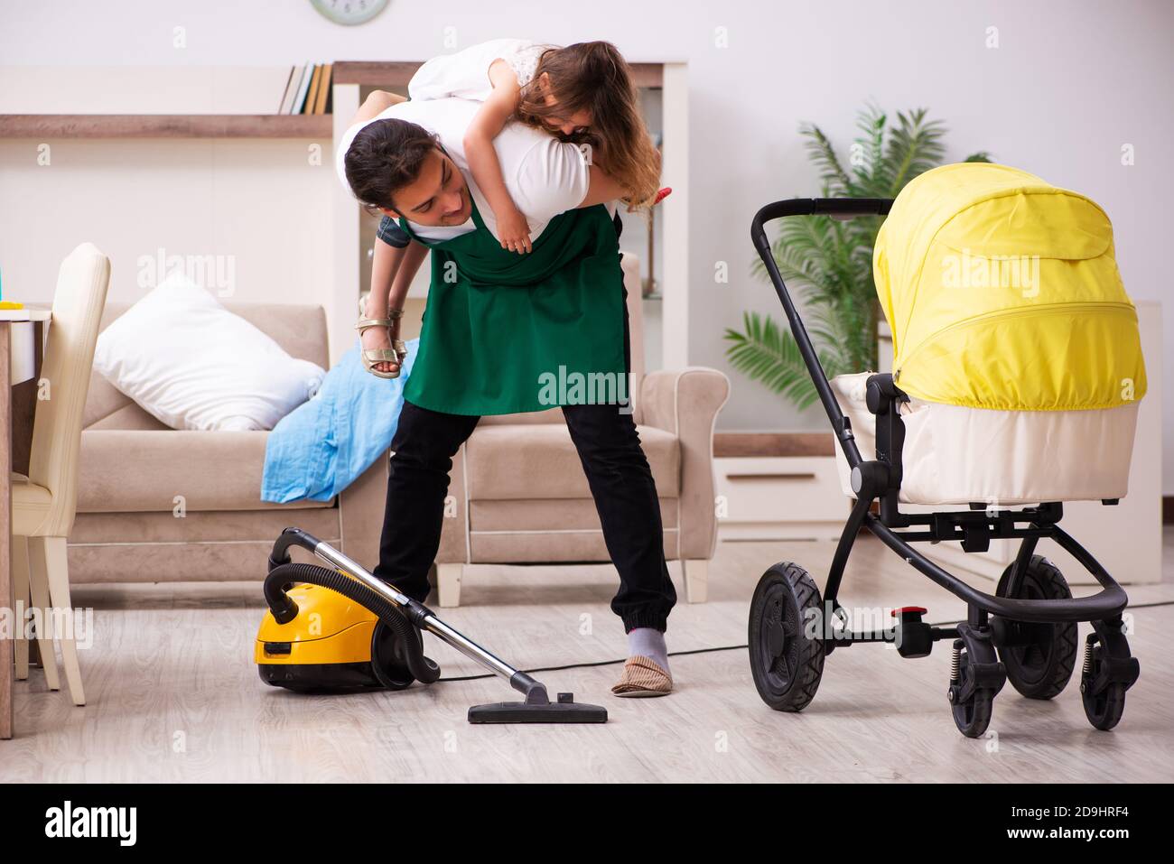 Young contractor cleaning the house with his small daughter Stock Photo ...