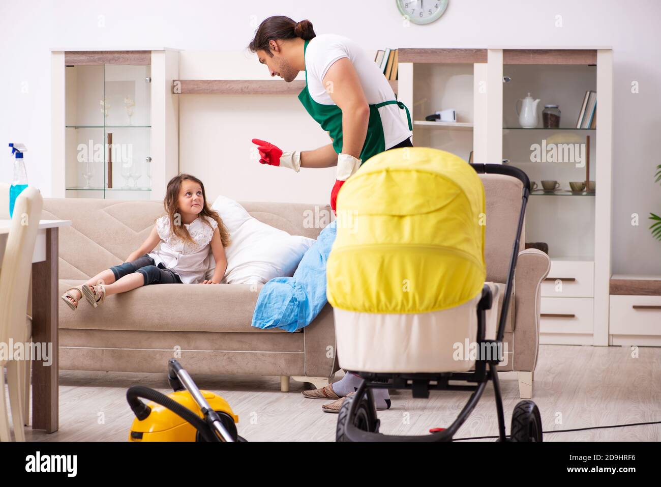Young contractor cleaning the house with his small daughter Stock Photo ...
