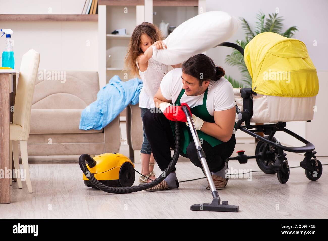 Young contractor cleaning the house with his small daughter Stock Photo ...