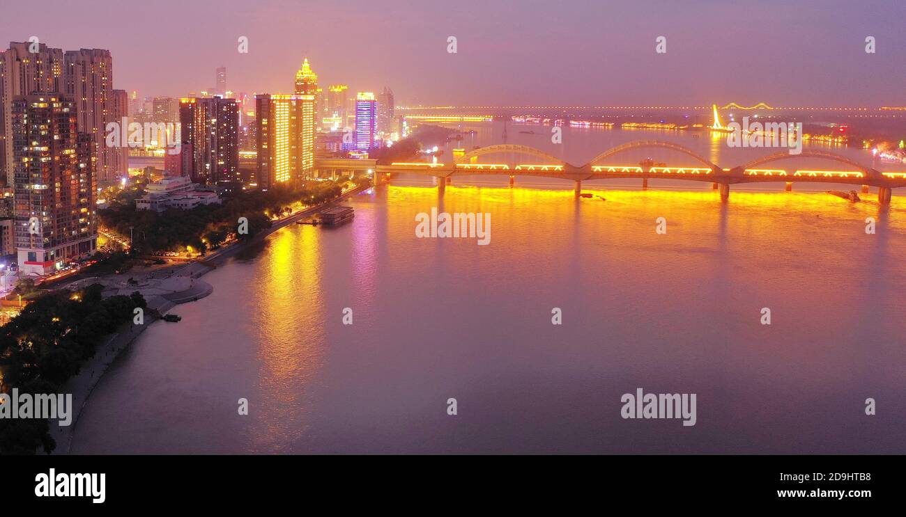 An aerial view of the whole urban area lighting up as night arrives and ...