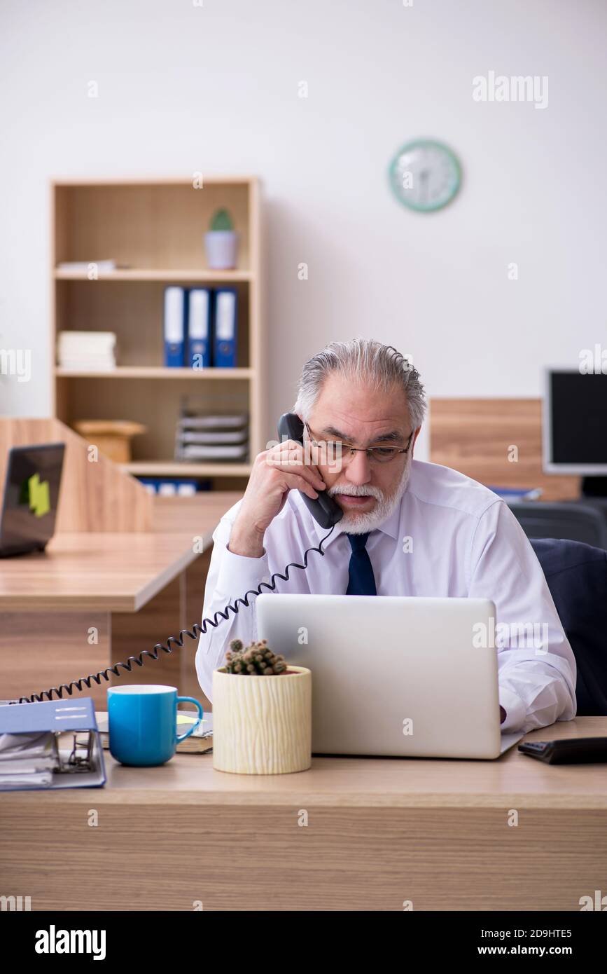 Old employee working in the office Stock Photo - Alamy