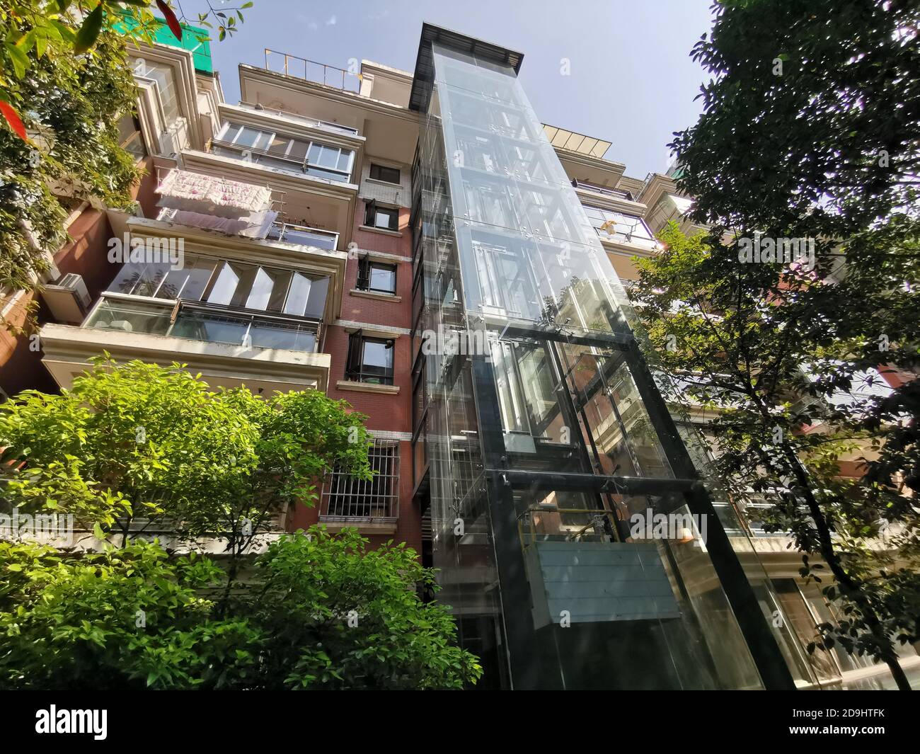 An elevator is built on the outside of an old apartment building to ...