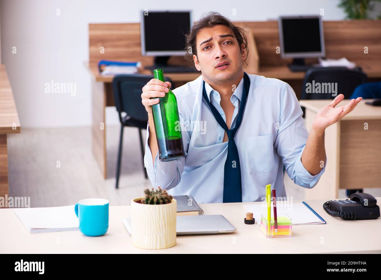 Male employee drinking alcohol at workplace Stock Photo - Alamy