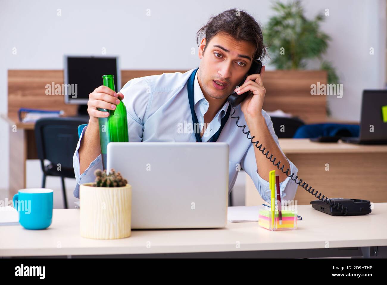 Male employee drinking alcohol at workplace Stock Photo - Alamy
