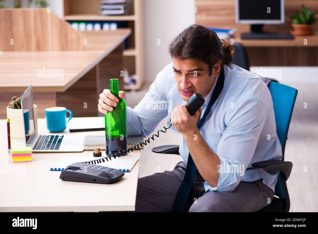 Male employee drinking alcohol at workplace Stock Photo - Alamy