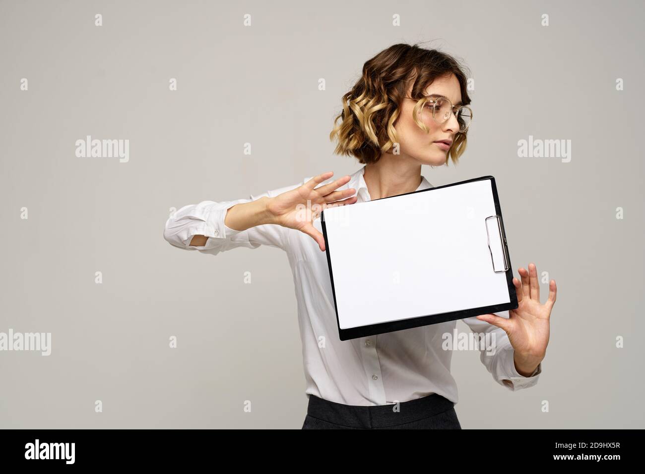 Business woman with folder of documents in hands on gray background ...