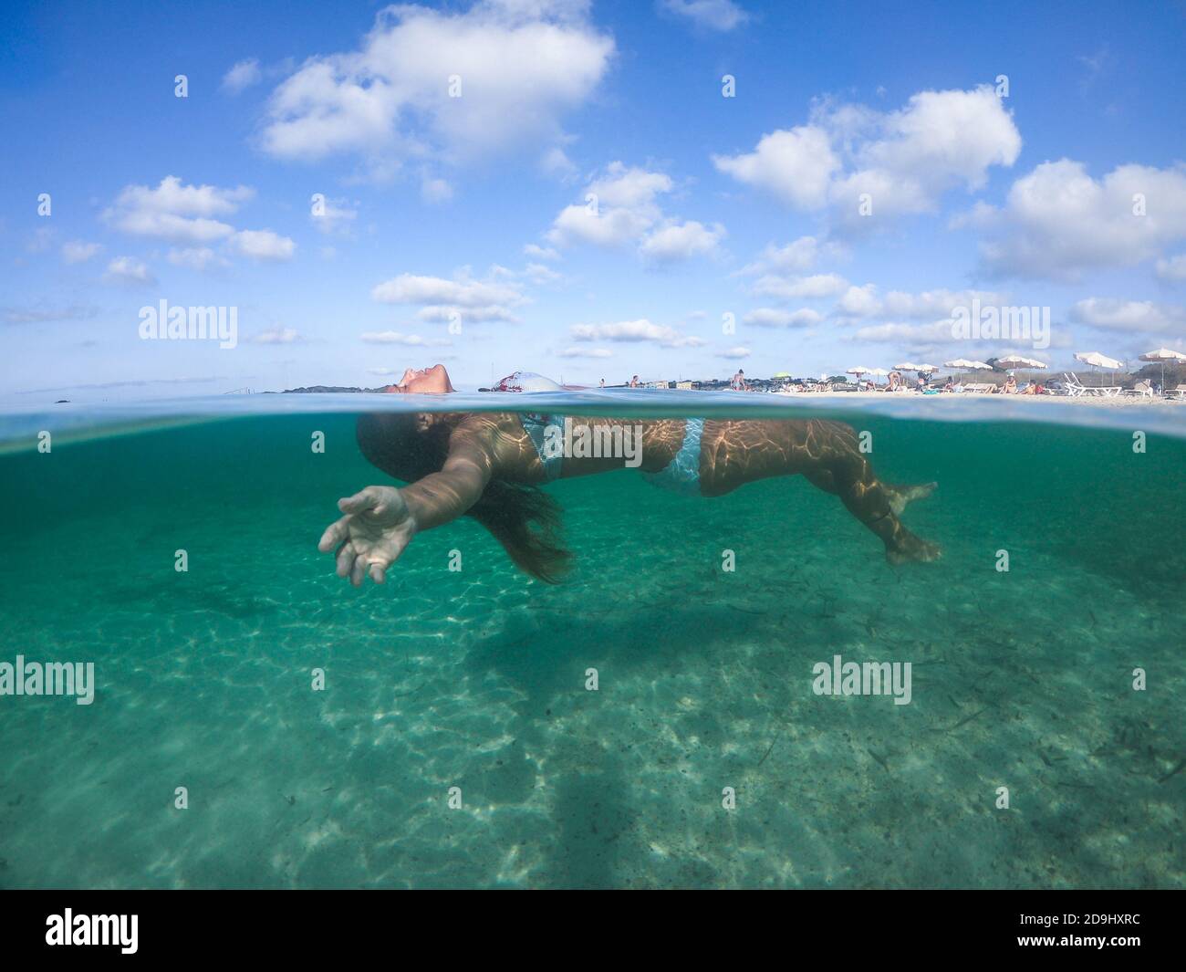 Woman floating face up in sea water, very relaxed. Formentera island ...