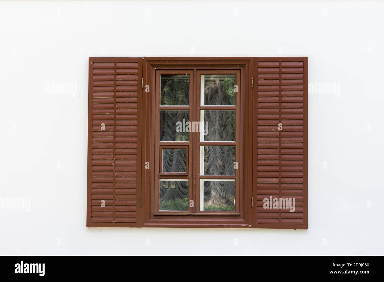 Window with brown wooden shutters and white wall Stock Photo - Alamy