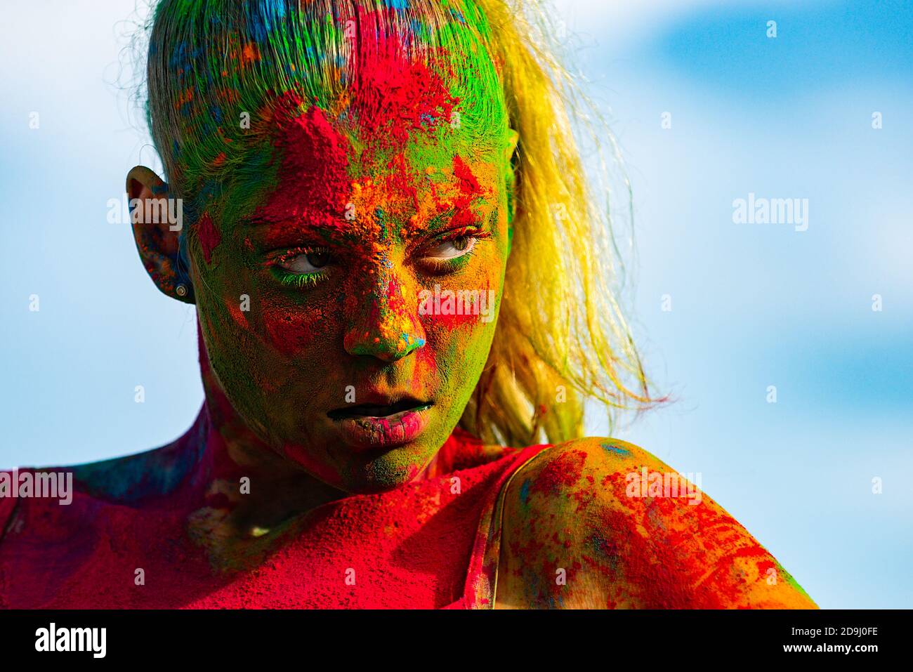 Portrait of young woman with paint make-up. Color face with colorful ...