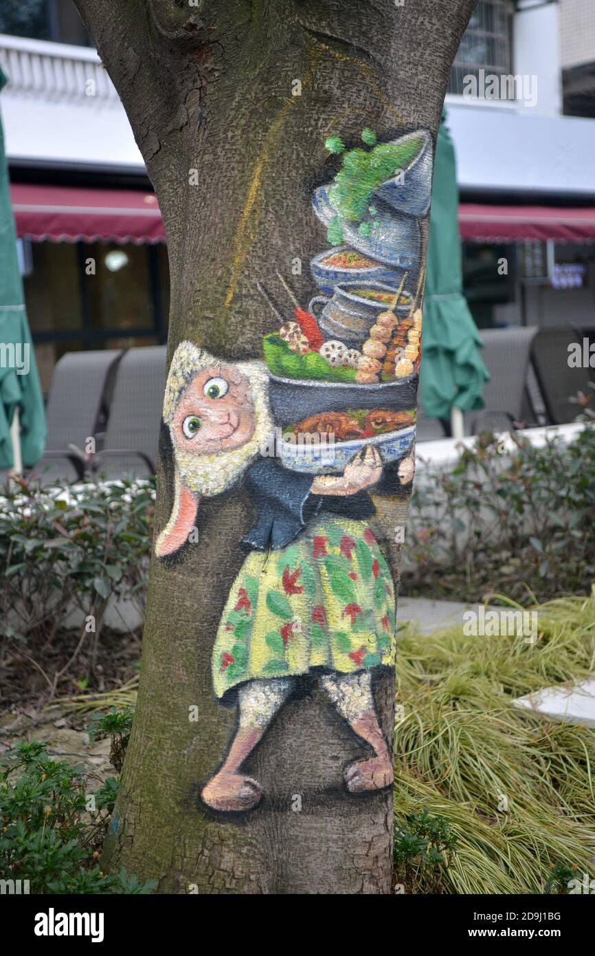 More than ten trees on a street are painted with graffiti, showing the ...