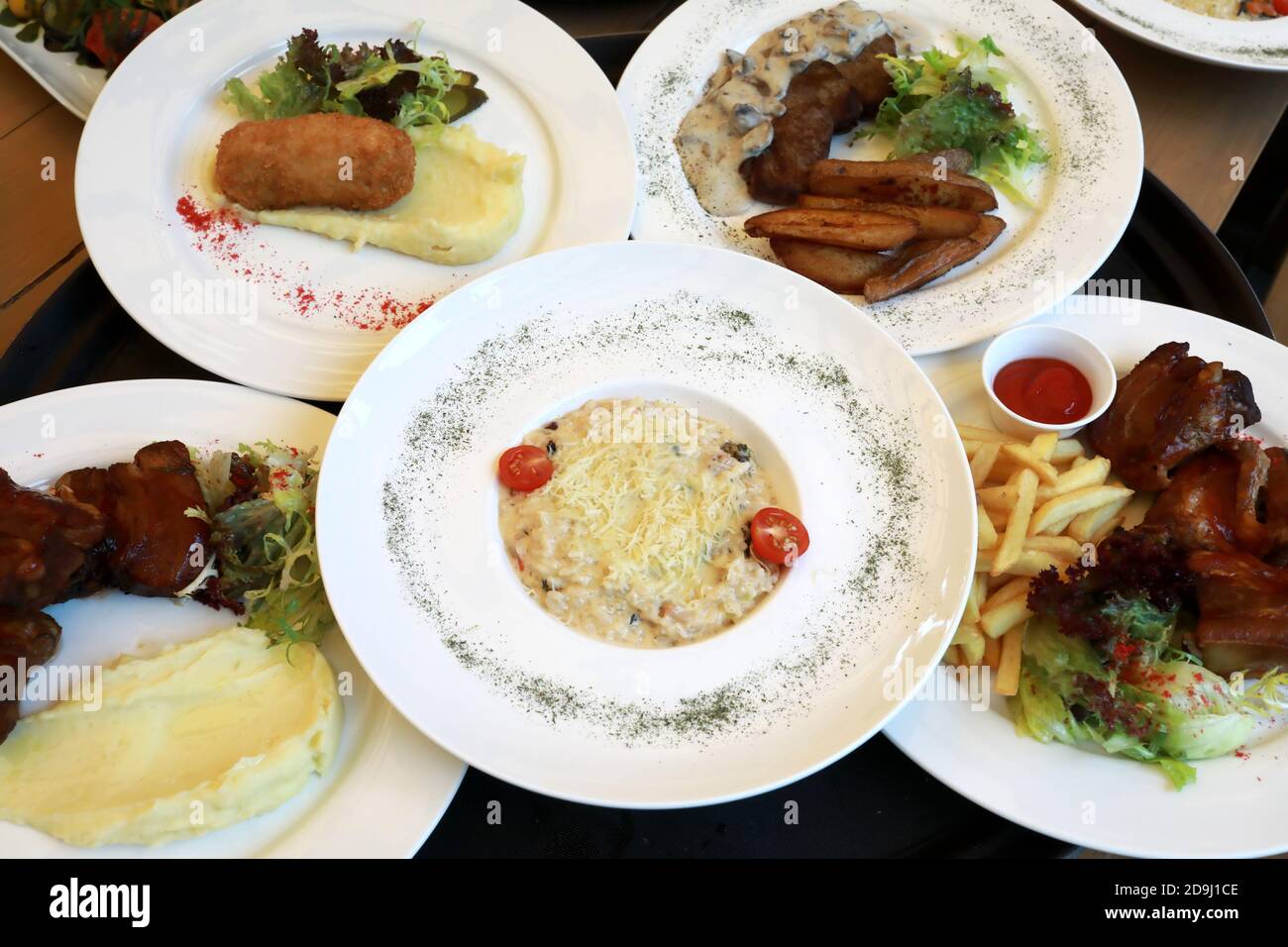 Plates with various dishes on tray in restaurant Stock Photo - Alamy
