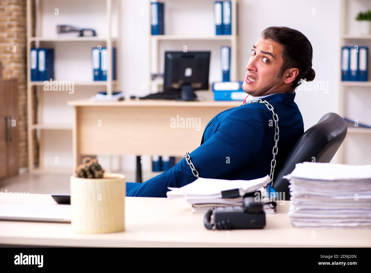 Chained employee working in the office Stock Photo - Alamy