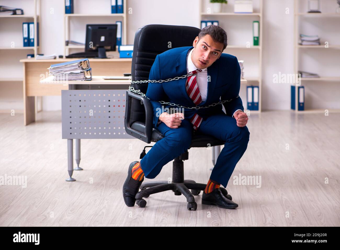 Chained employee working in the office Stock Photo - Alamy