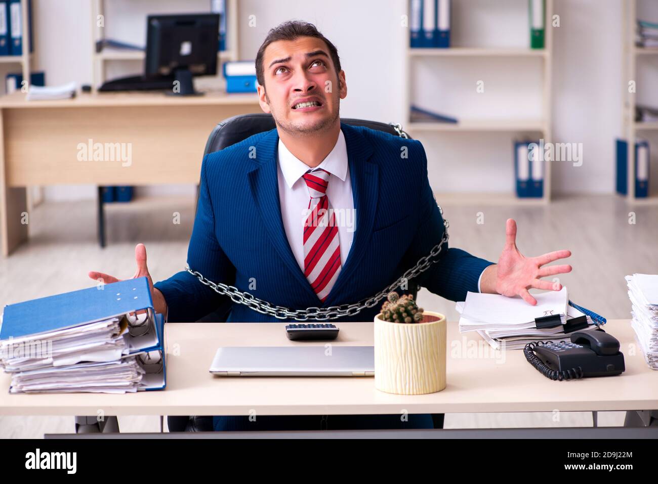 Chained employee working in the office Stock Photo - Alamy