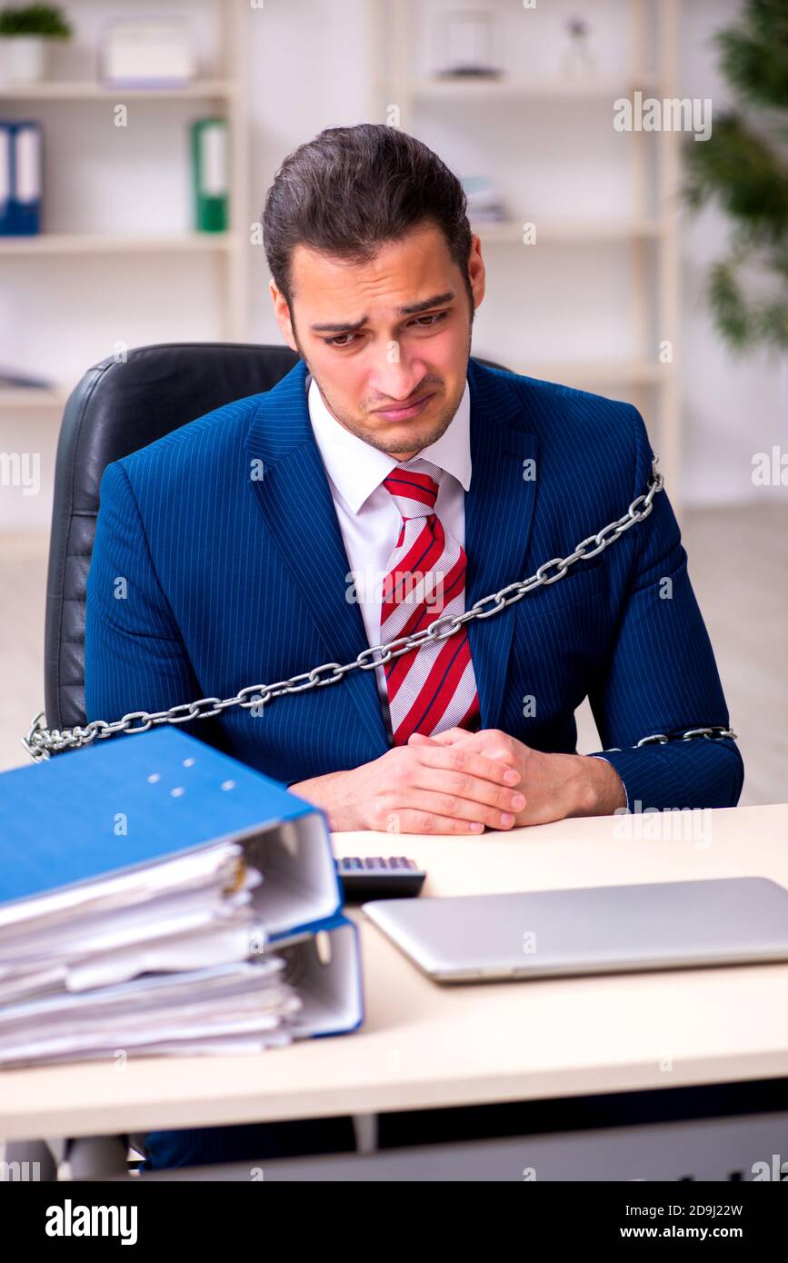 Chained employee working in the office Stock Photo - Alamy