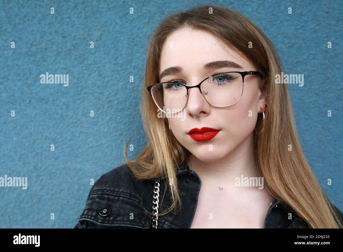 Portrait of teen on blue cement wall background Stock Photo - Alamy