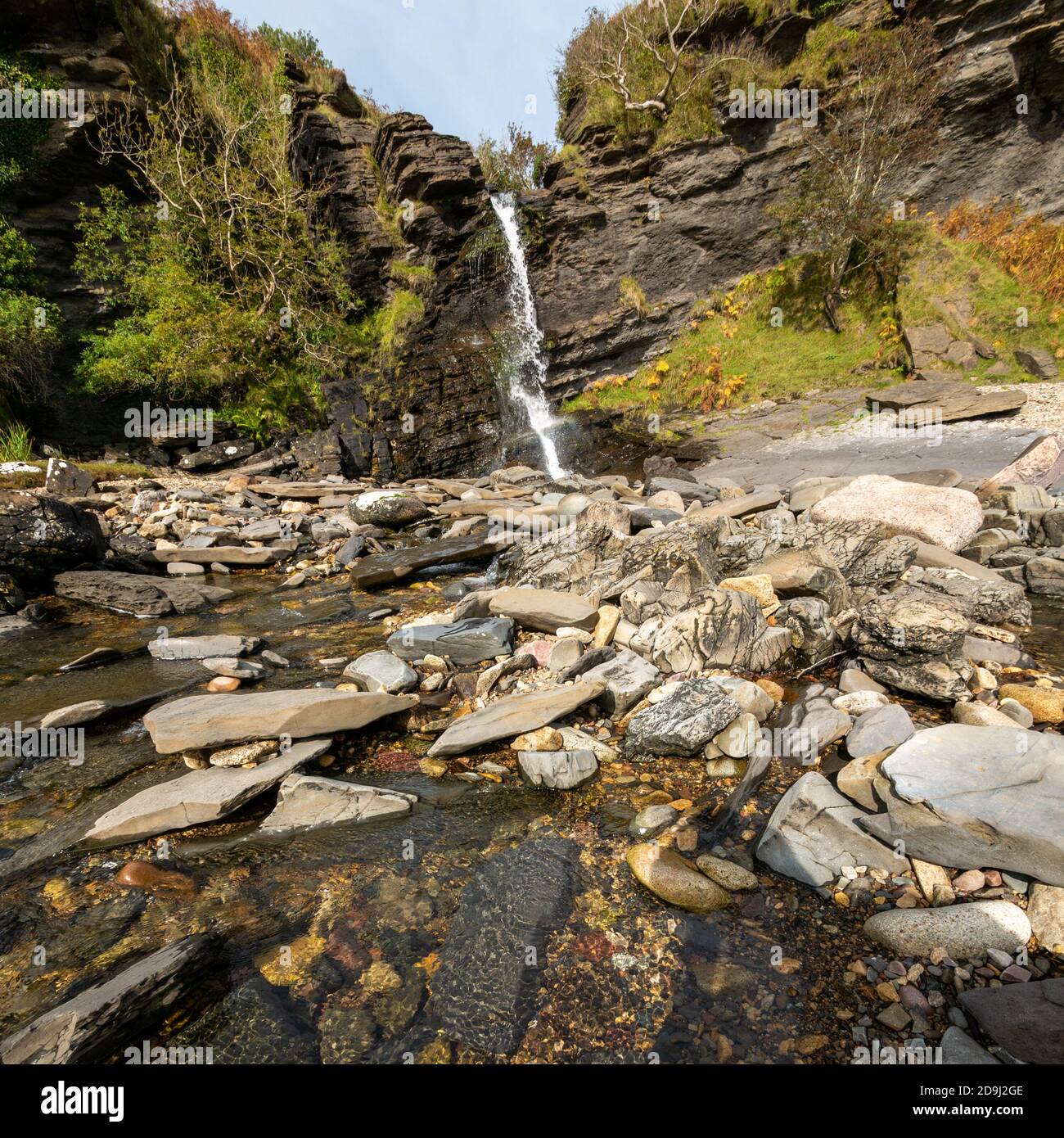 Waterfall on Allt na Pairte river as it plunges over sea cliffs into a ...